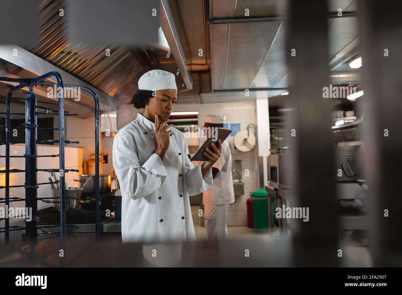 Portrait of mixed race female professional chef using tablet with ...