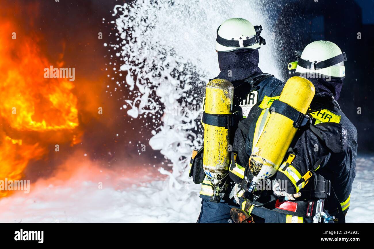 Firefighter - Firemen extinguishing a large blaze, they are standing ...