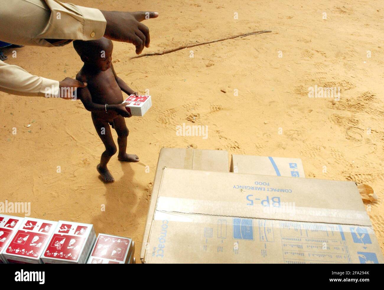 A SMALL BOY HOLDING AN EMERGENCY FOOD RATION AT A FEEDING CENTRE RUN BY ...