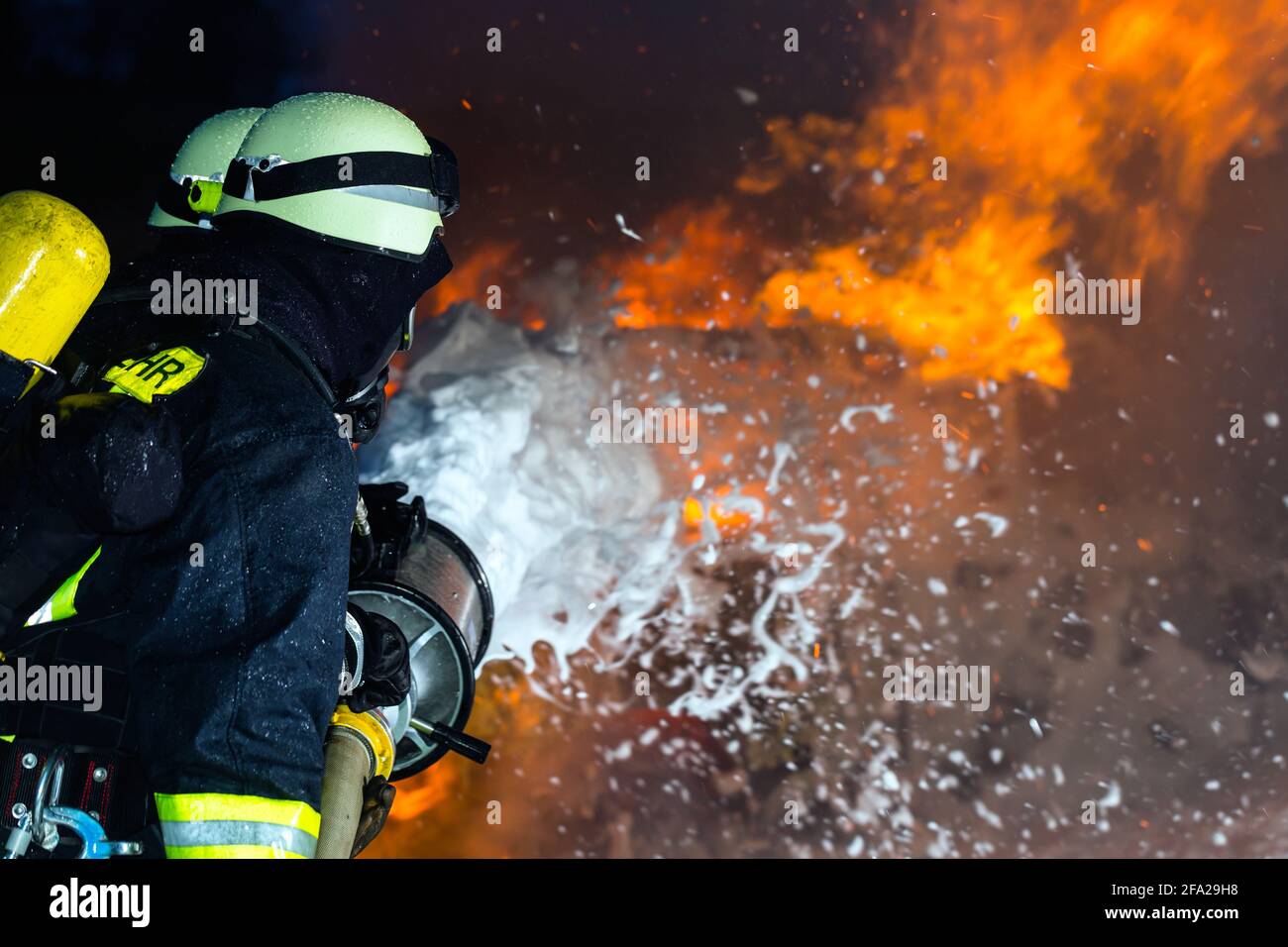 Firefighter - Firemen extinguishing a large blaze, they are standing ...