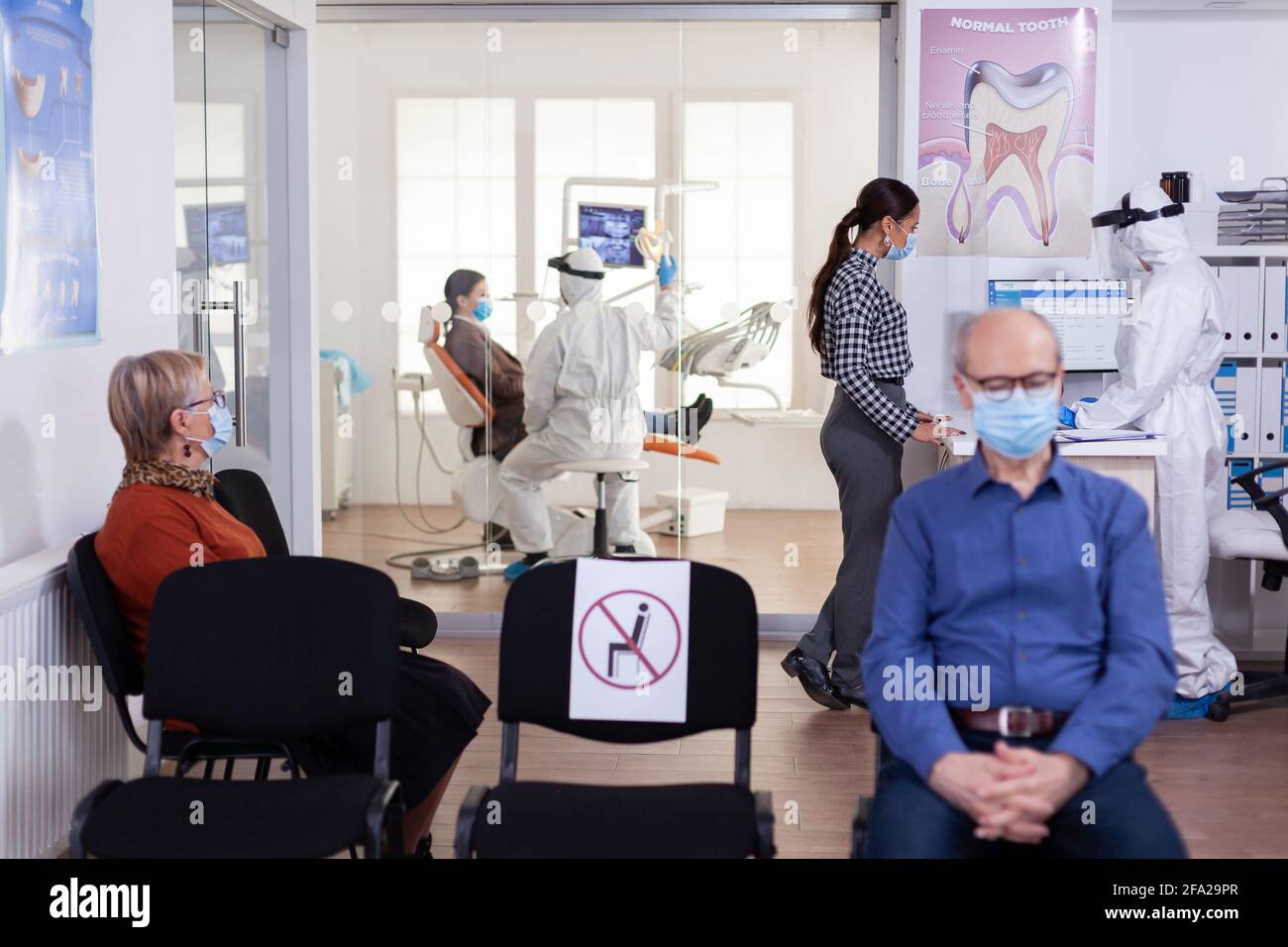 Dentist nurse dressed in ppe suit with face shiled discussing with ...