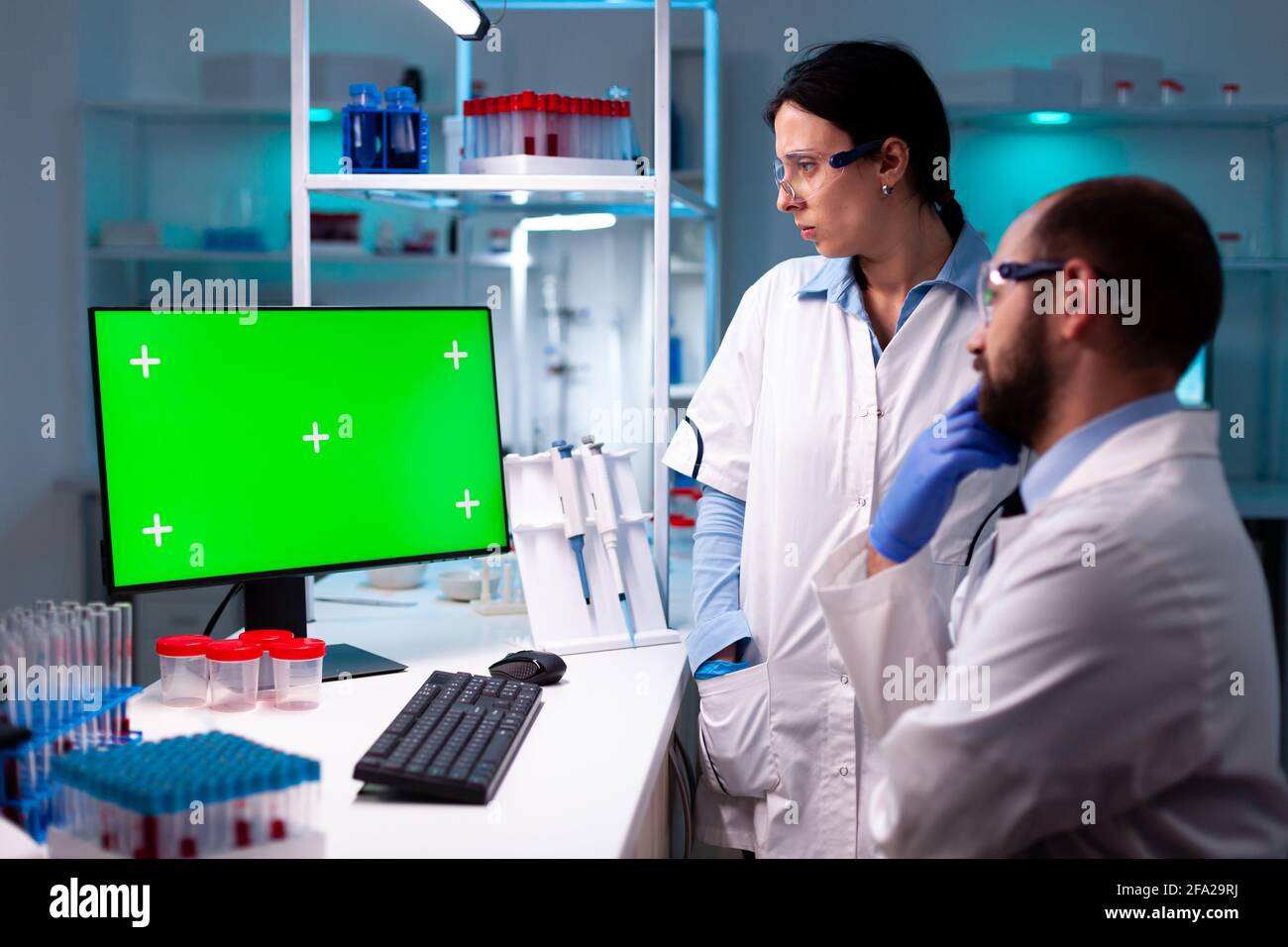Team of scientist working and analyzing using computer with green ...