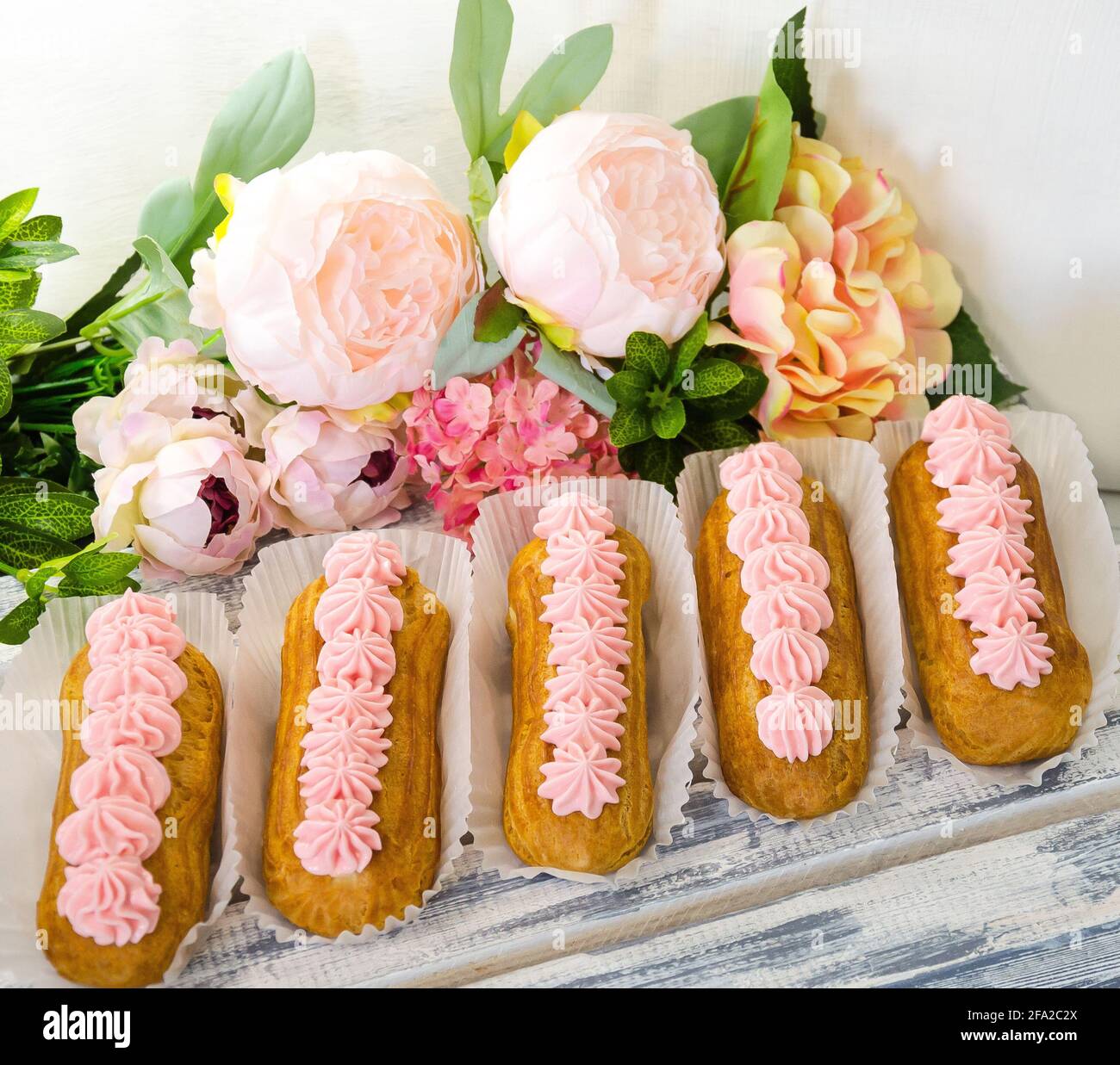 Yummy vanilla eclairs on wood with flower decoration Stock Photo - Alamy