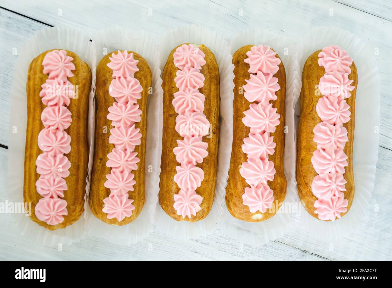 Yummy vanilla eclairs on wood with flower decoration Stock Photo - Alamy