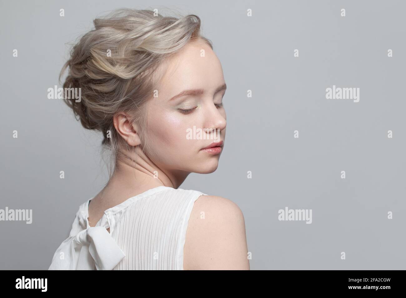 Pretty blonde woman with updo hairstyle on white background Stock Photo ...