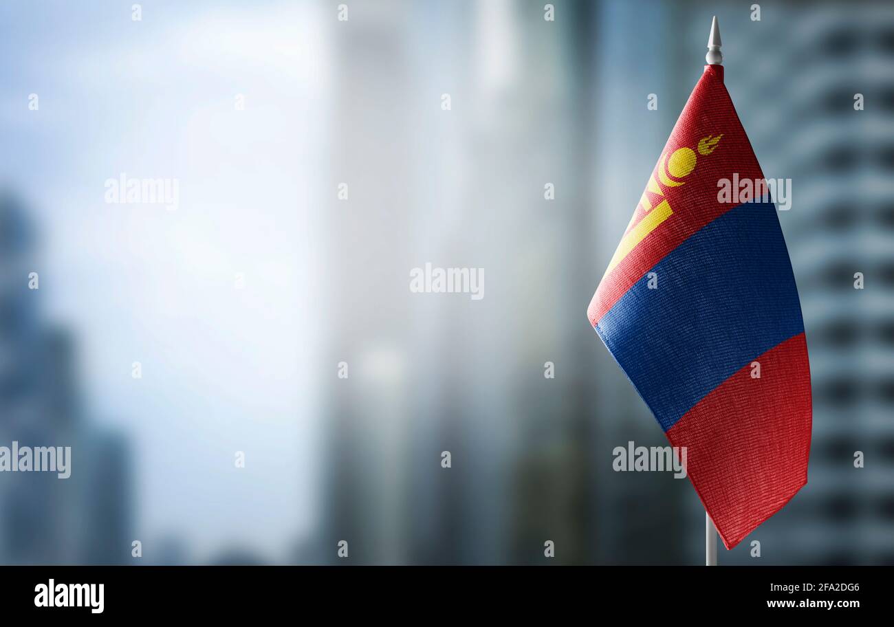 A small flag of Mongolia on the background of a blurred background ...