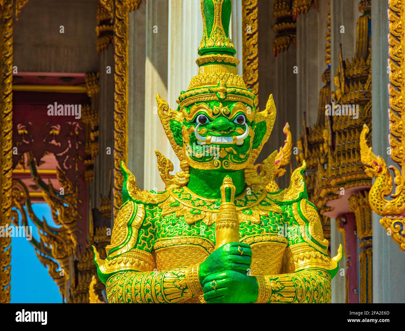 Giant temple guardian Yaksha in gold green at colorful Wat Don Mueang ...