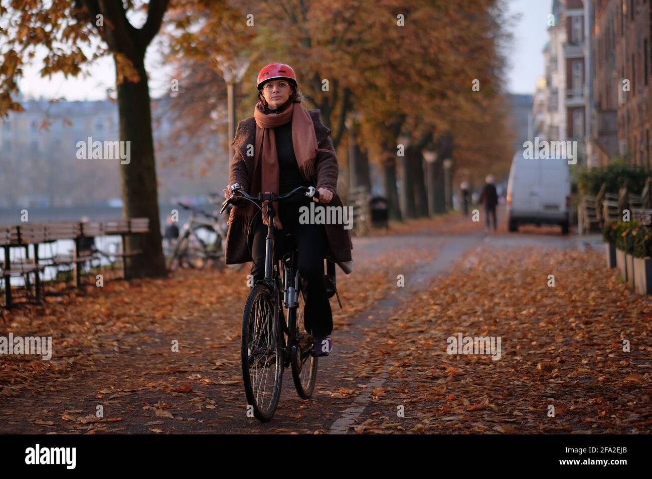 Copenhagen, Denmark 12 October 2017. Woman riding a bicycle in a helmet ...
