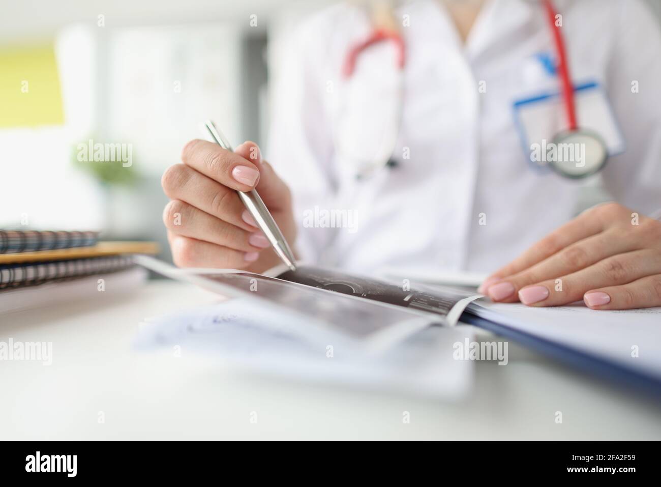 Hands of doctor holding and examining ultrasound scan Stock Photo - Alamy