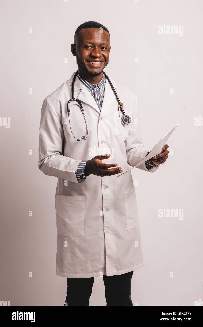 black skinned young medic smiling standing on a white background with ...