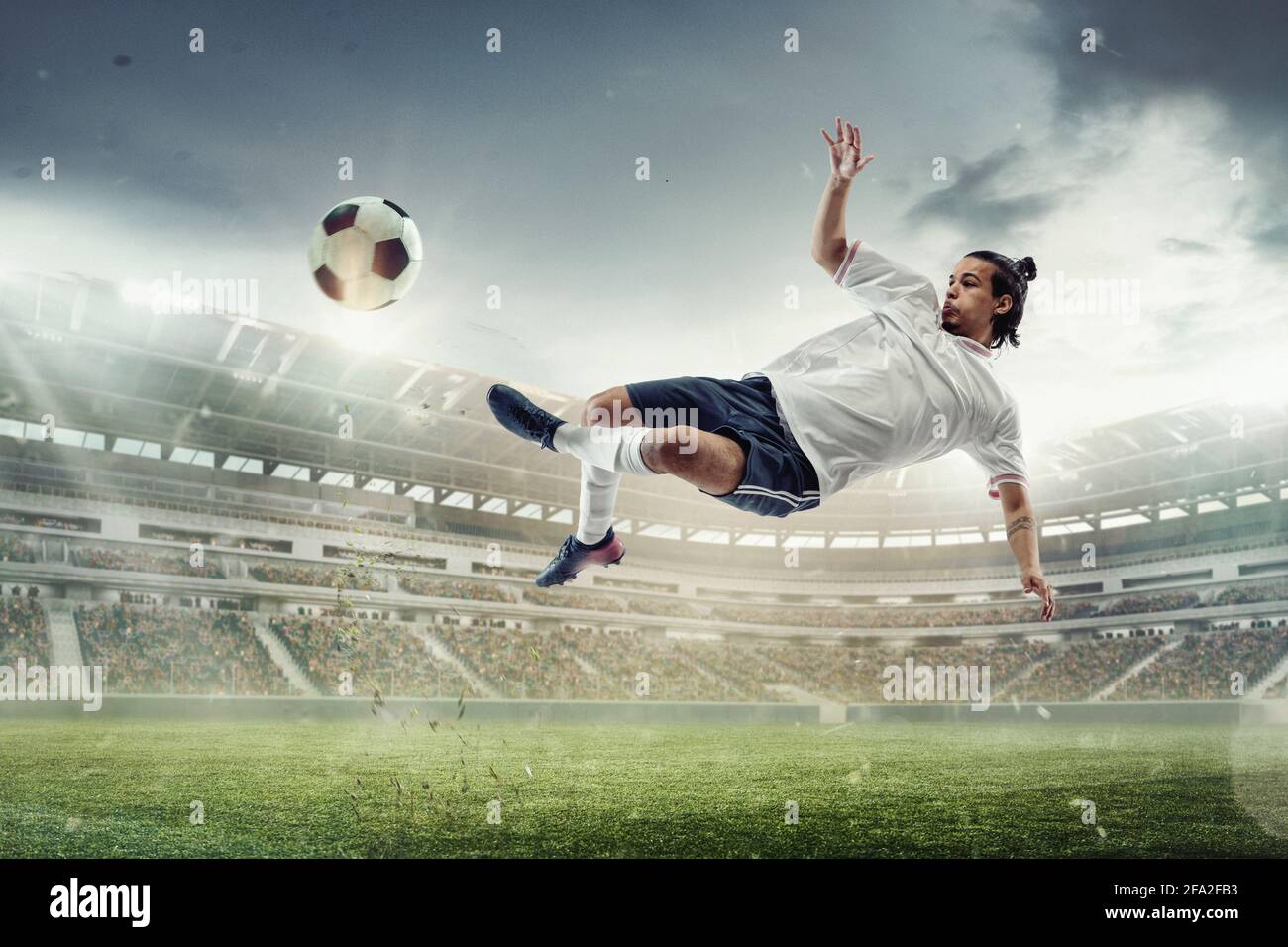 Male soccer, football player catching ball in jump at the stadium ...