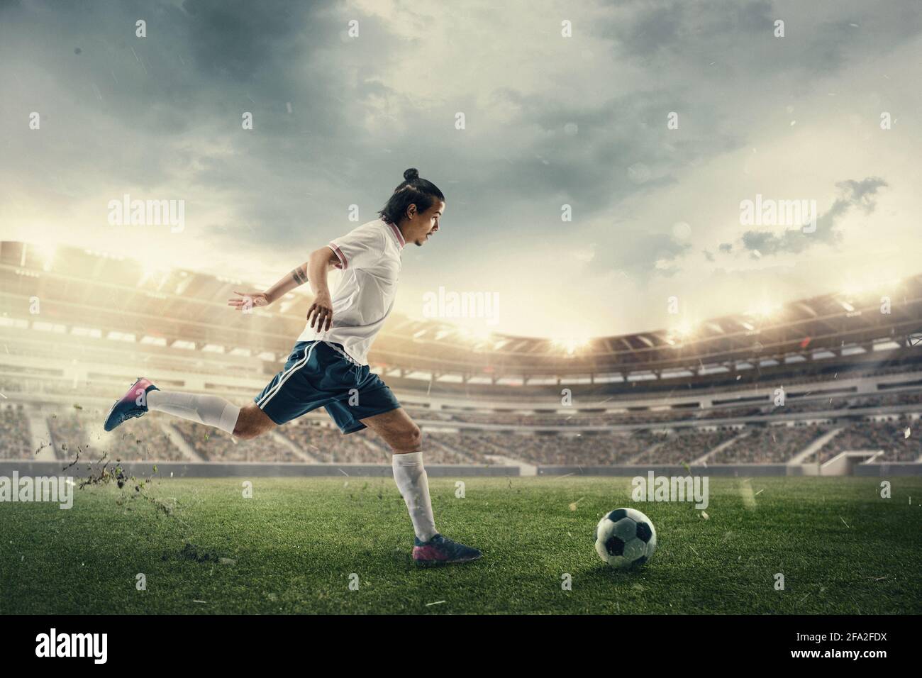 Male soccer, football player catching ball in jump at the stadium ...