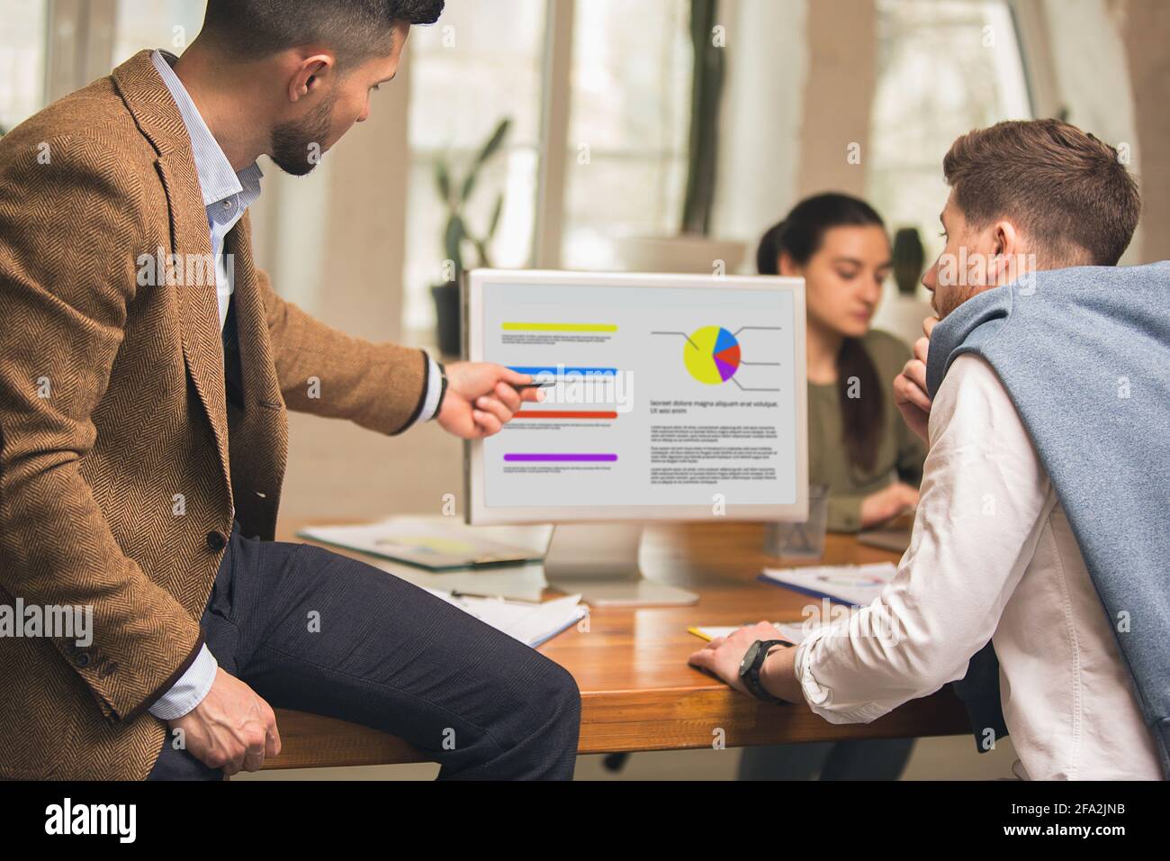 Colleagues working together in modern office using devices and gadgets ...