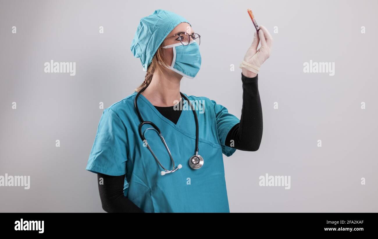 Female doctor examines a blood sample for the Corona virus Stock Photo ...