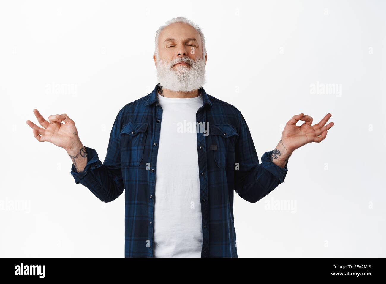 Stylish old man with tattoos relaxing and meditating, breathing with ...