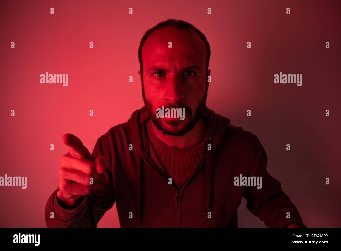 concept af angry and abusive man with red light. studio portrait of ...