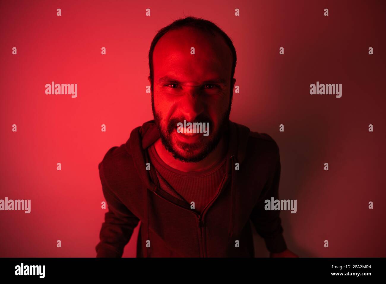 concept af angry and abusive man with red light. studio portrait of ...