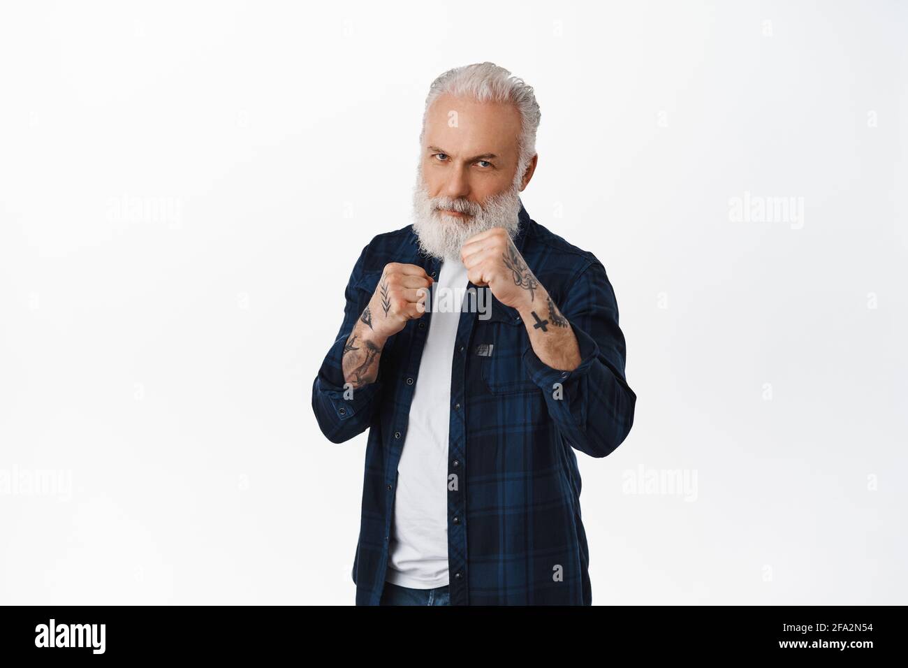 Sassy old man with tattoos raising fists for fight, standing in boxing ...