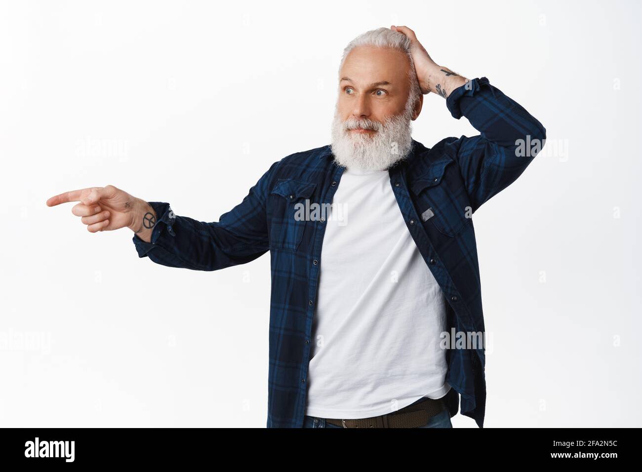 Confused senior guy pointing finger left at something surprising ...
