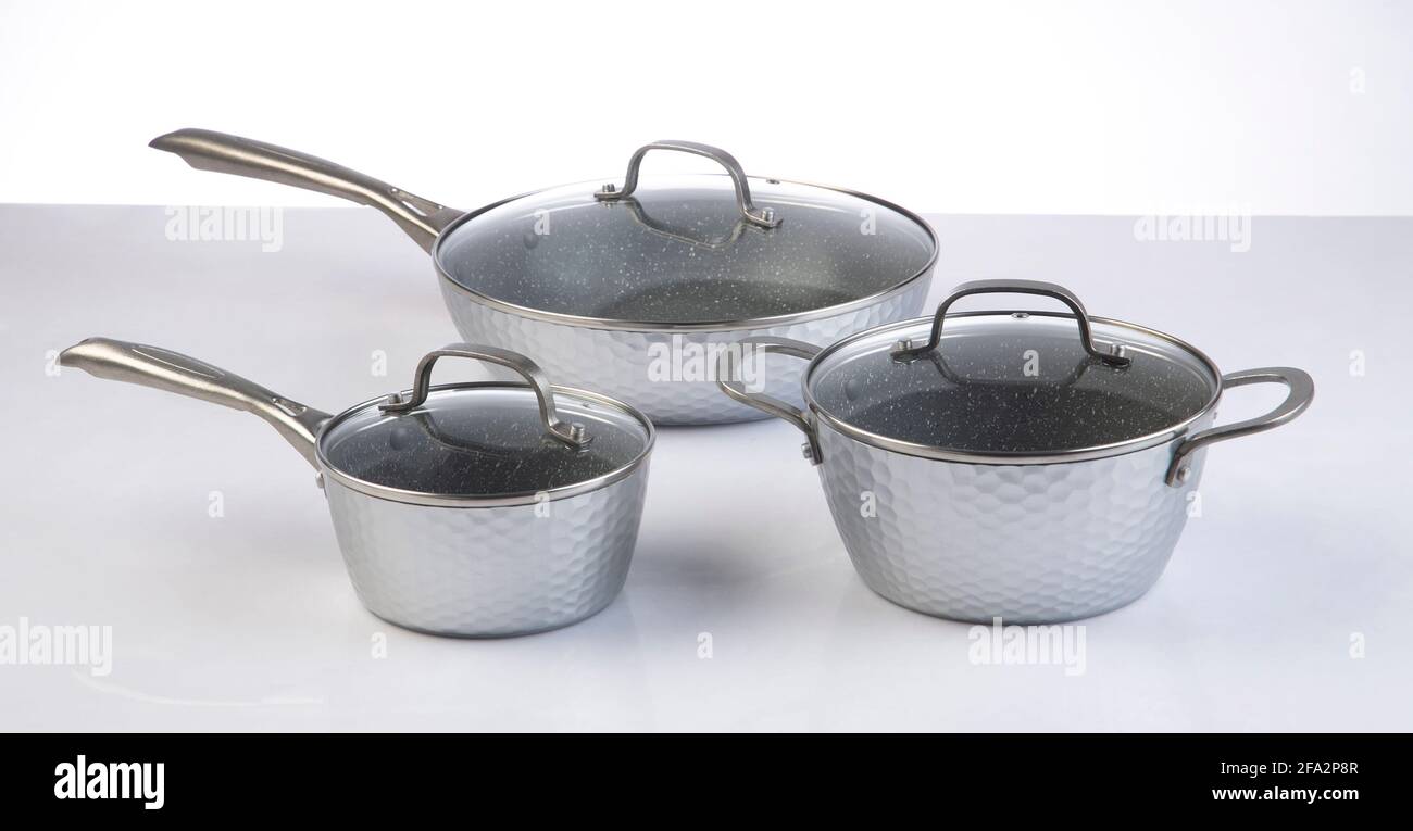 Set of empty stainless steel pots and pan with glass lids isolated on ...