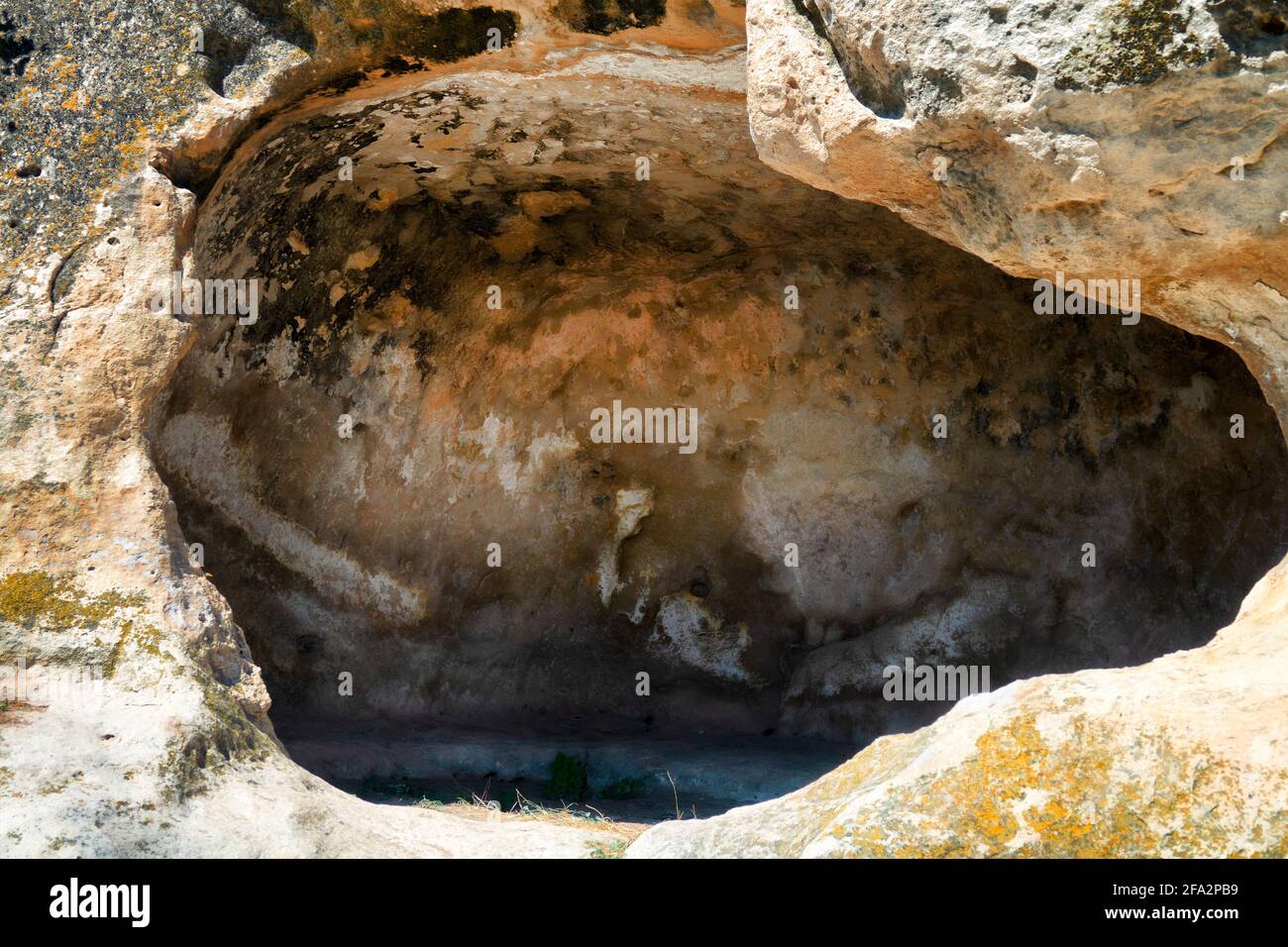 Entrance to a man-made cave in a limestone rock. A place of refuge for ...