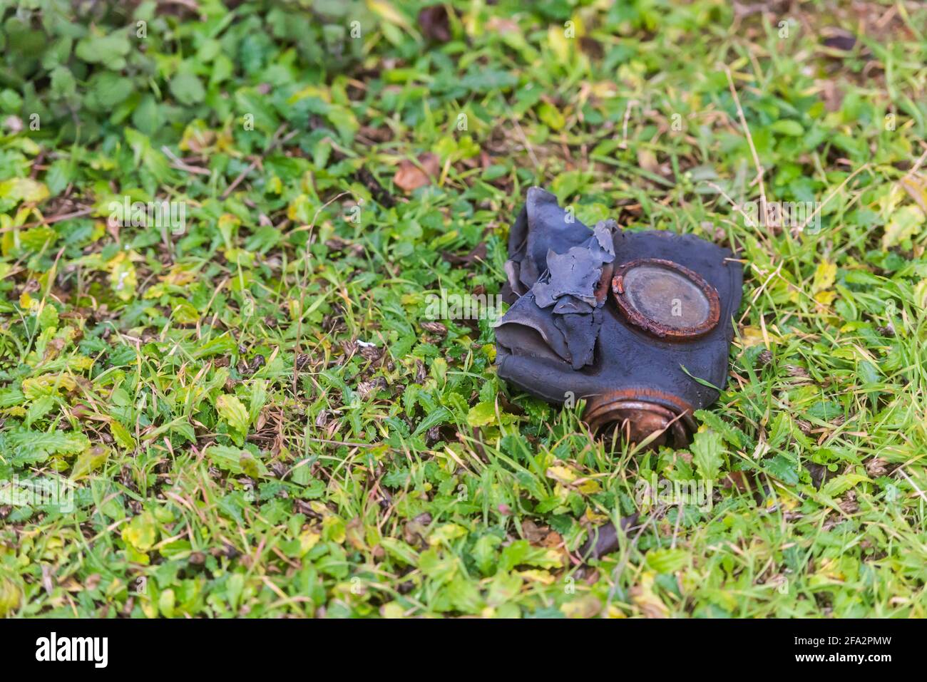 Old gas mask on the grass. Soviet remnants in old garrisons. A rusty ...