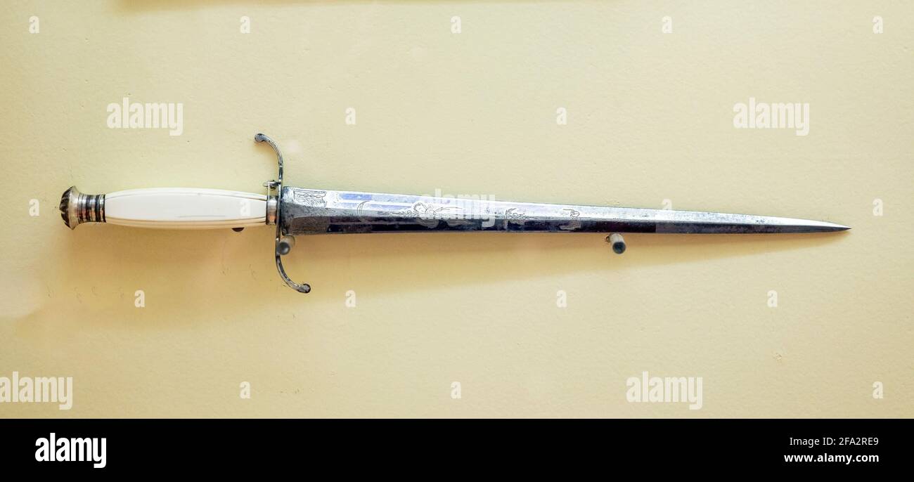 Sword isolated on a yellow background Stock Photo - Alamy