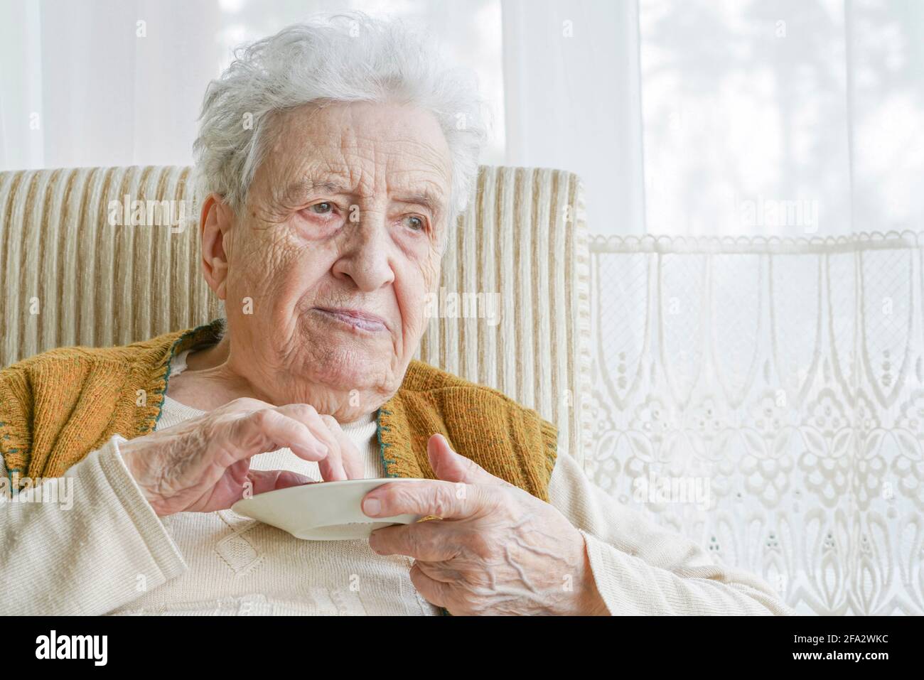 a senior woman woman eating something at home Stock Photo - Alamy