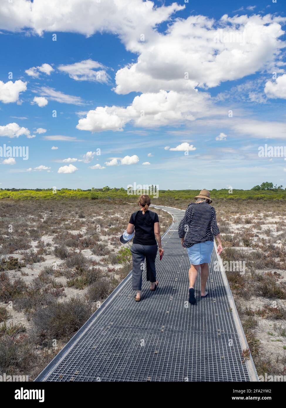 Two Caucasian women walking on a raised path around Lake Thetis Western ...