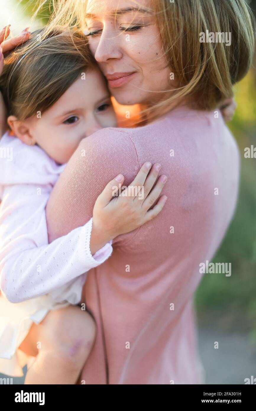 Portrait of european mother hugging little daughter and smiling Stock Photo - Alamy