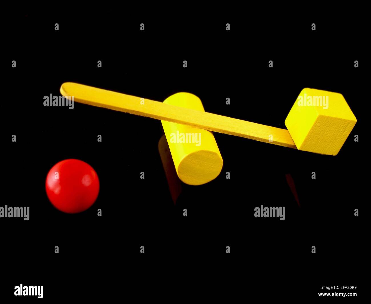 Conceptual image with colorful objects where the cube has outweighed a ...