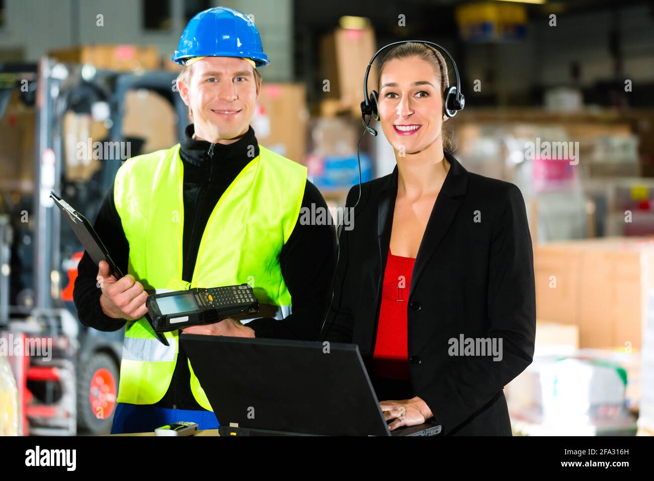 Teamwork - warehouseman or forklift driver and female supervisor with ...