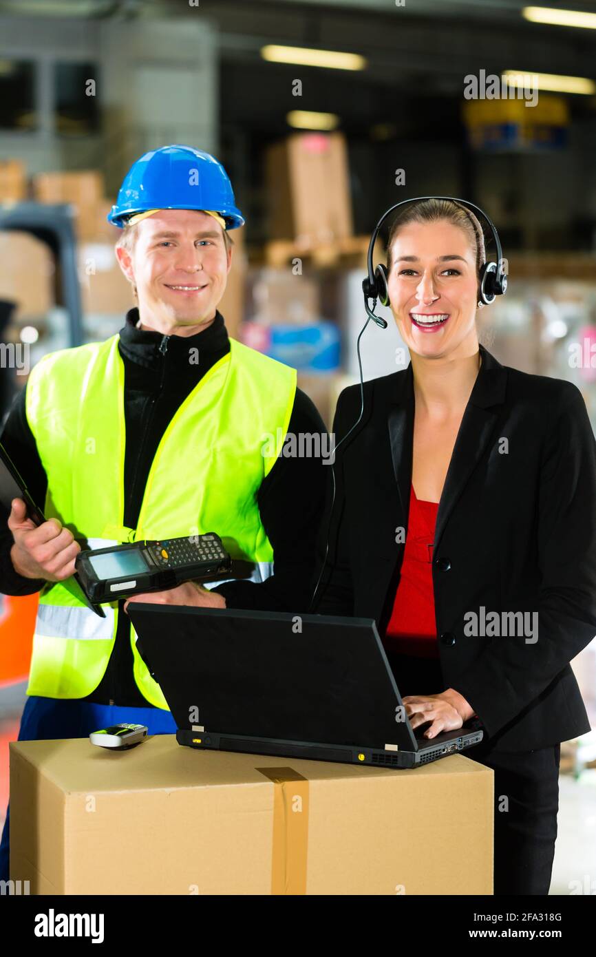 Teamwork - warehouseman or forklift driver and female supervisor with ...