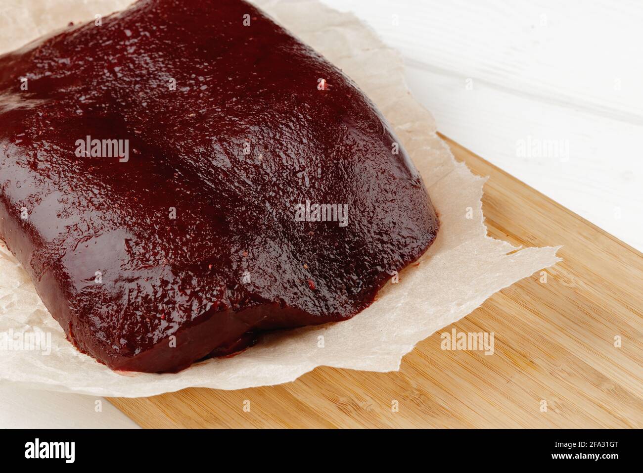 Raw beef liver on wooden board on table Stock Photo - Alamy