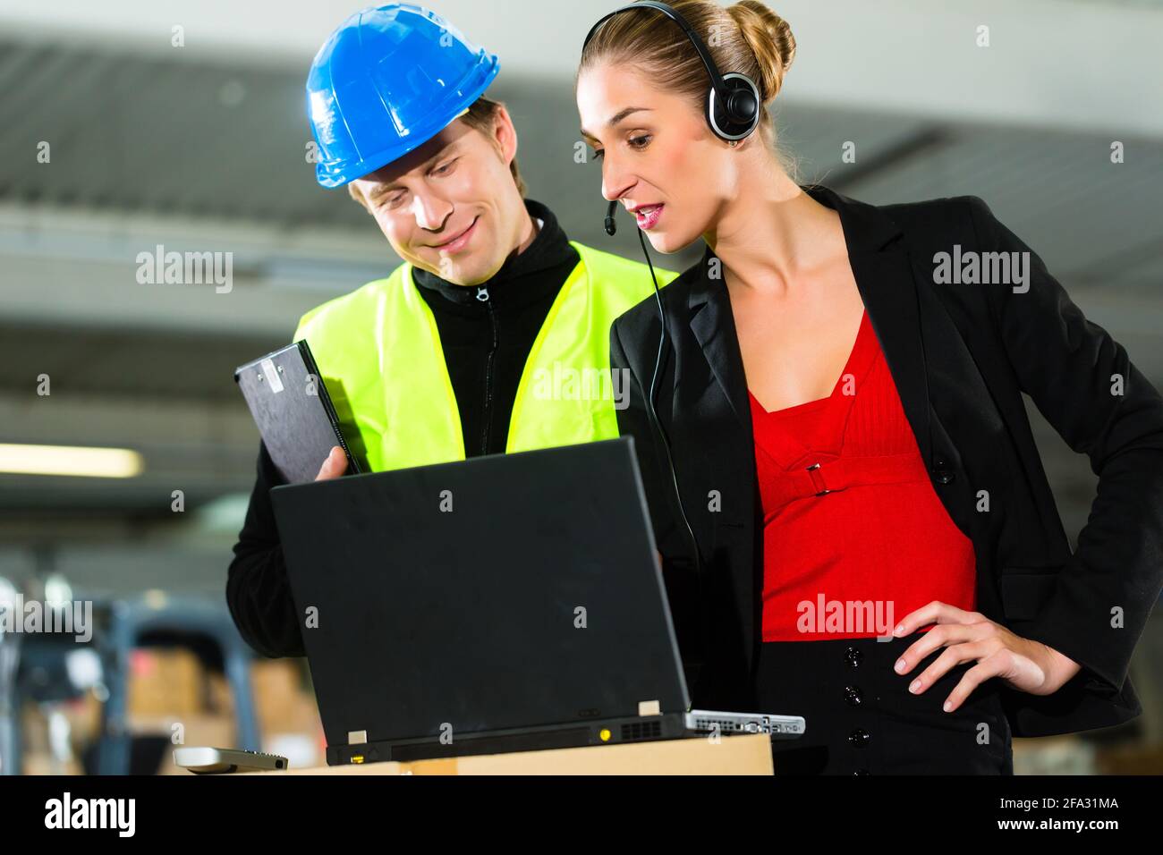Teamwork - warehouseman or forklift driver and female supervisor with ...