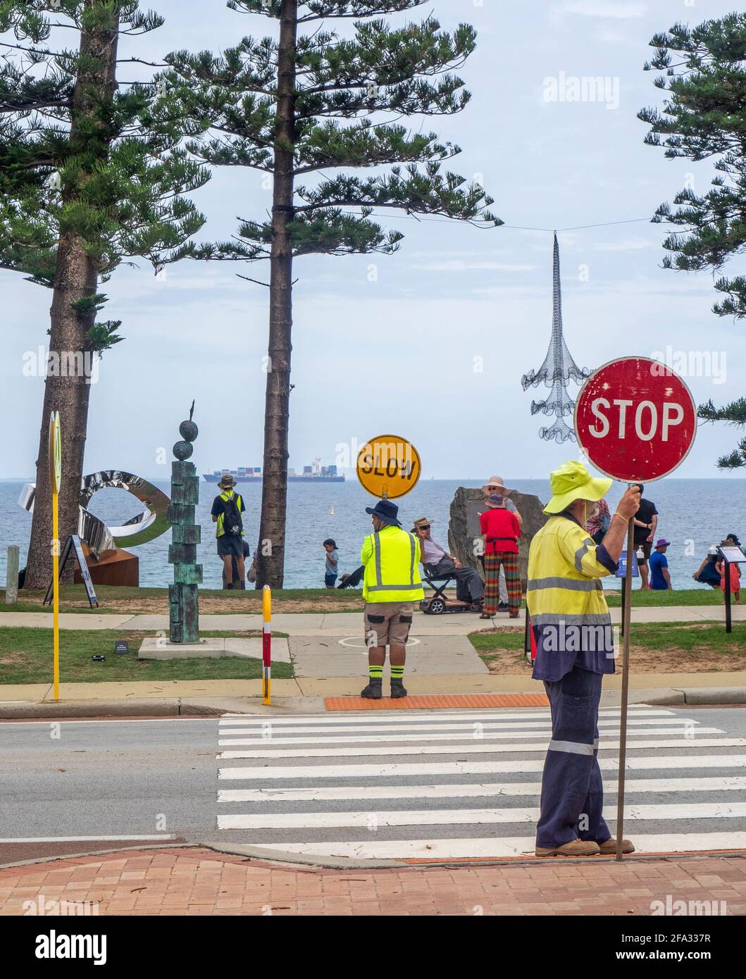 Lollipop men or traffic management men holding Stop and Slow signs at a ...