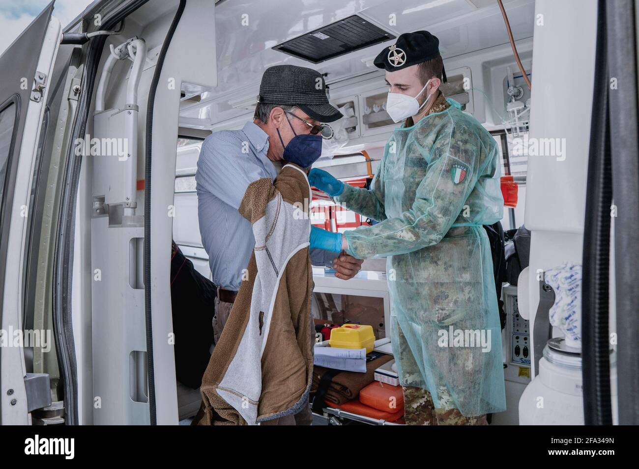 A member of the Medical Italian Army Task Force helps a man with his ...