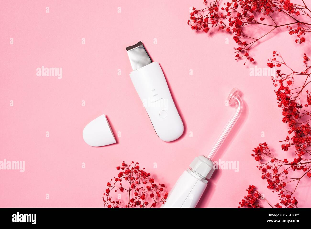 Ultrasonic water peeling and high-frequency beauty home devices on pink ...
