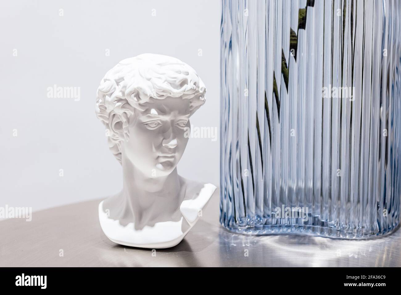 Stylish gypsum statue of David bust in living room or cafe interior ...