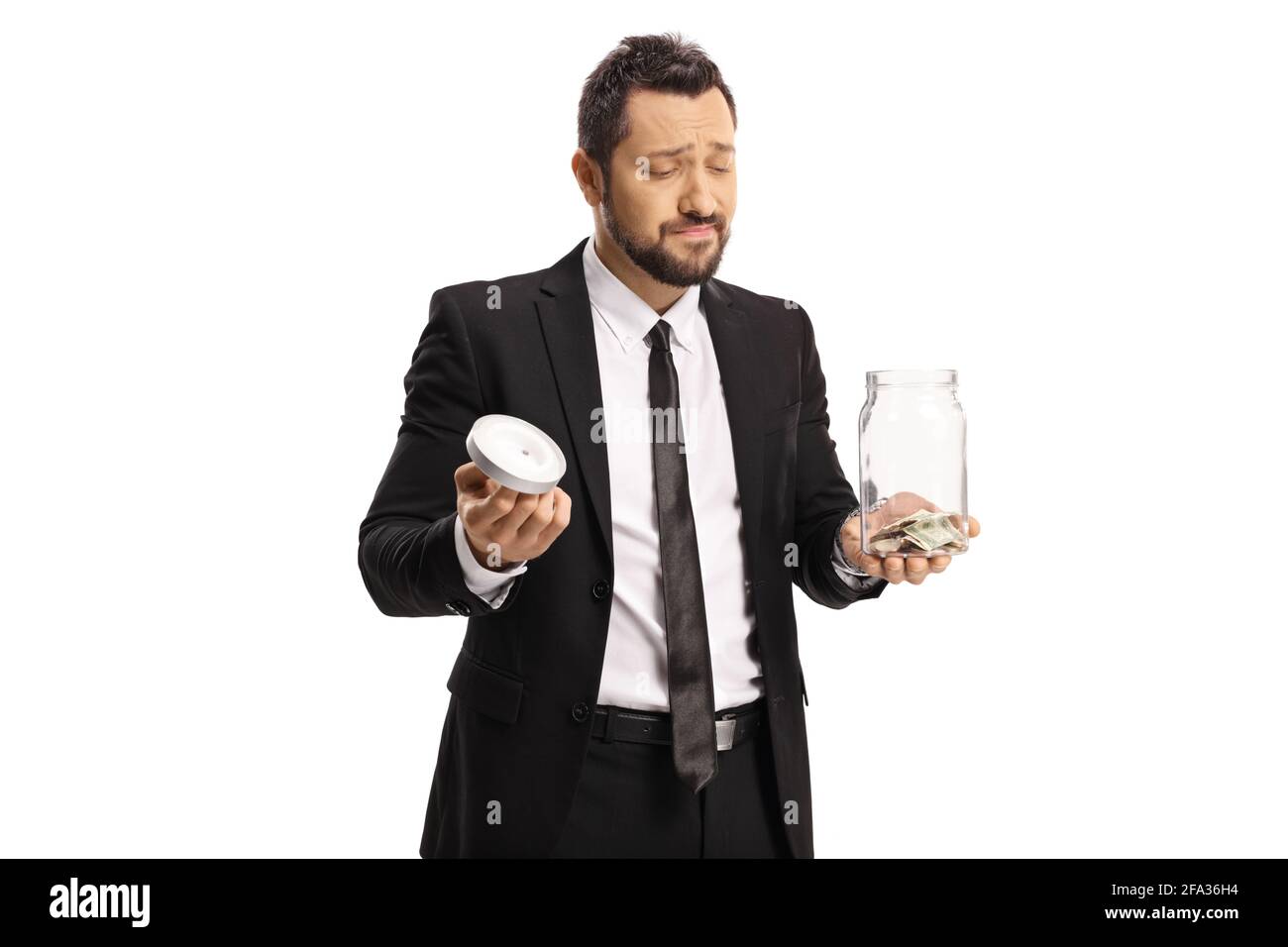 Sad businessman holding a glass jar with coins isolated on white ...