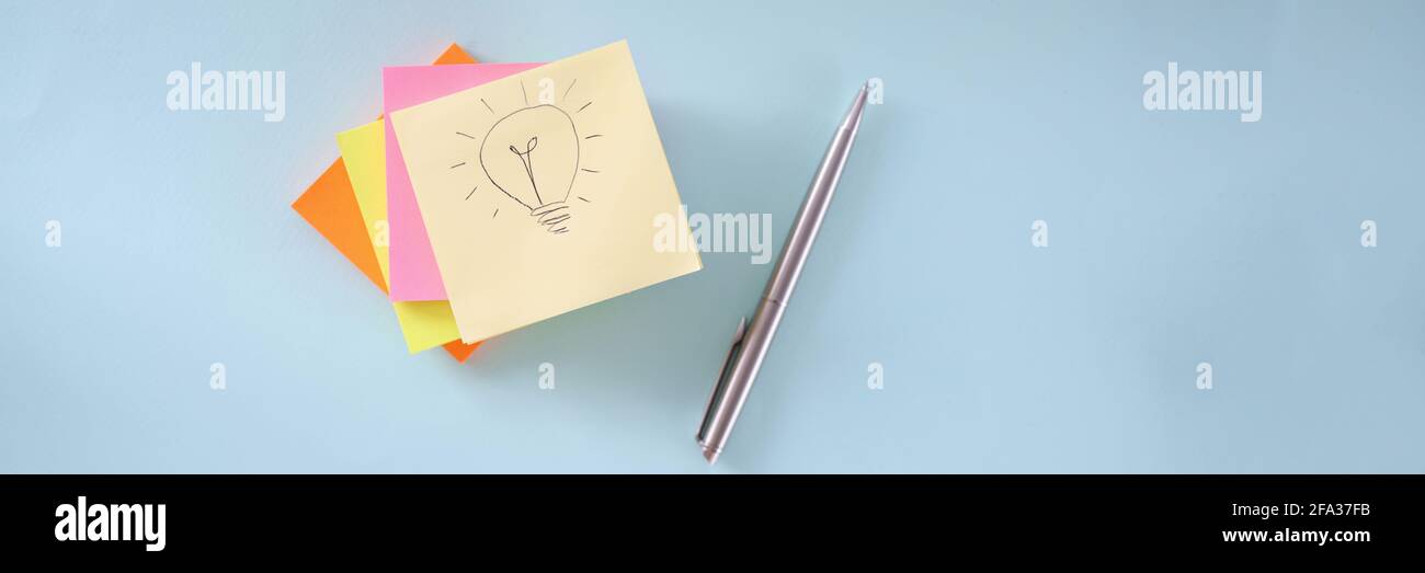 Light bulb is drawing on piece of paper. Many colorful stickers and ...