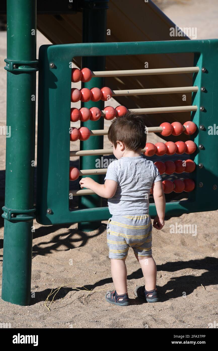young boy playing on playground equipment Stock Photo - Alamy