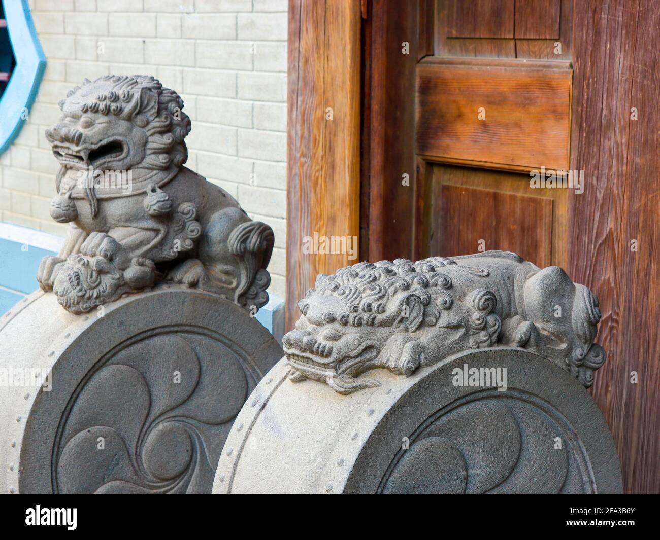 Classic, traditional stone carved Chinese dragon statues guard a wood ...