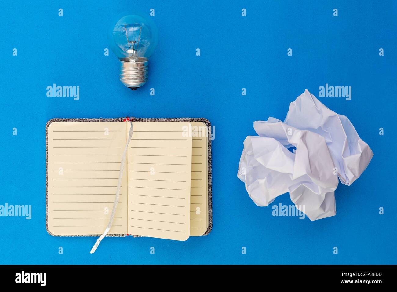 crumpled paper as if discarding ideas and a notebook to write down ...