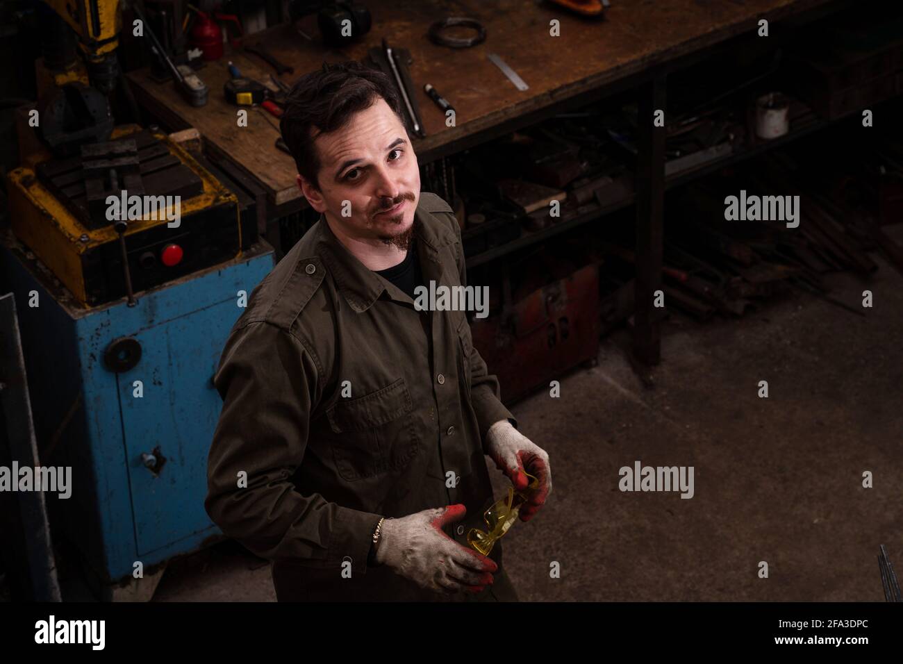 Traditional metalworking process in a forge. Portrait of a working man ...