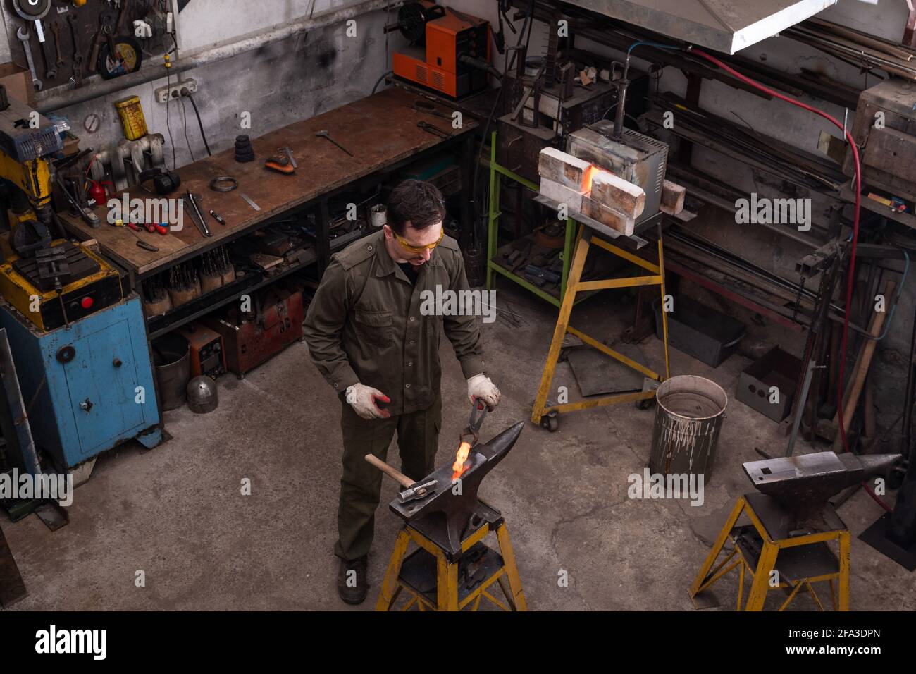 Traditional metalworking process in a forge.The master blacksmith works ...