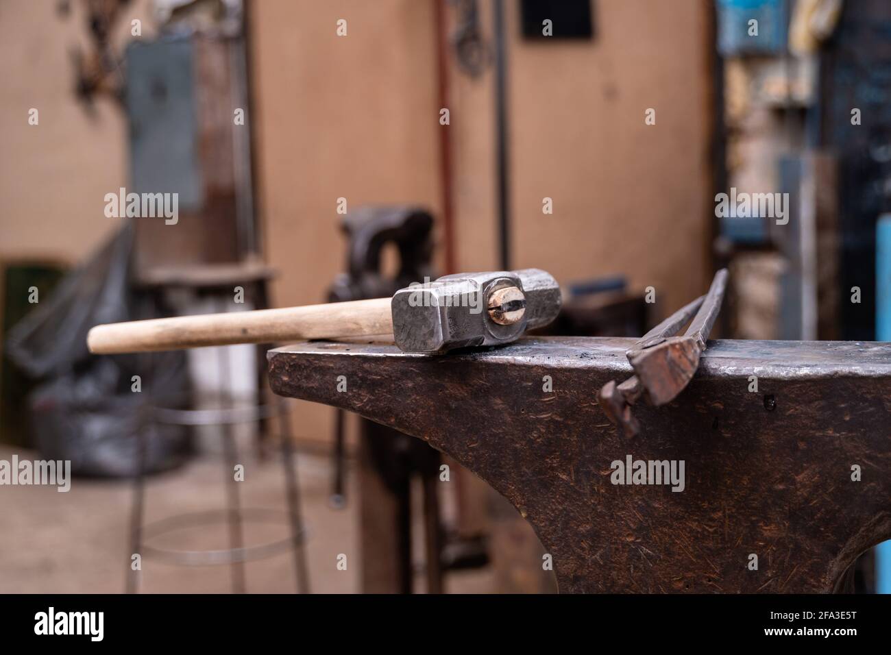 Tools for forging in a blacksmith shop. The hammer and pliers lie on ...