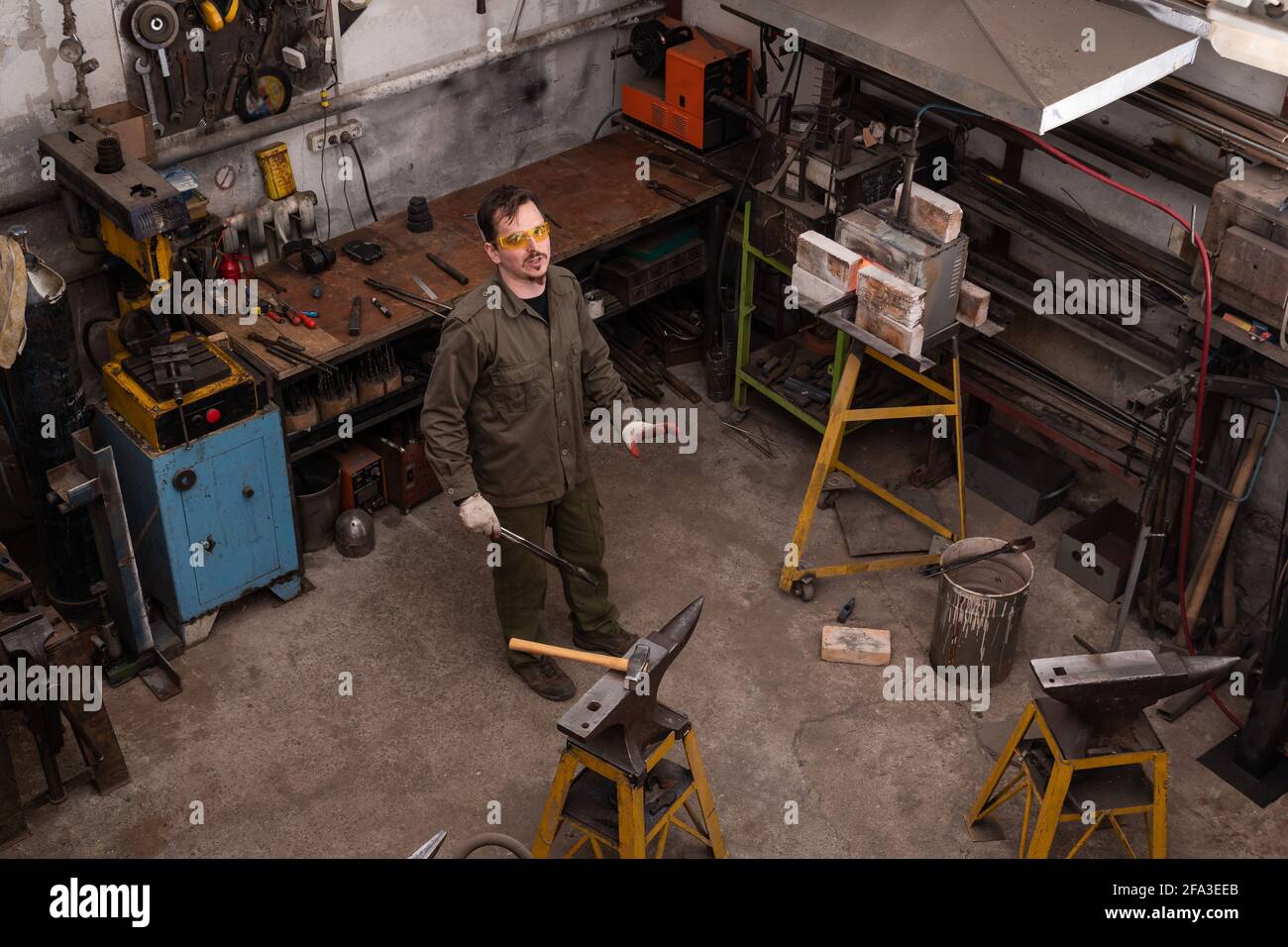 Traditional metalworking process in a forge. Blacksmith in the workshop ...
