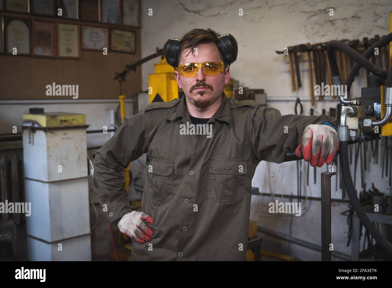 Portrait of a young modern artisan against the background of a ...