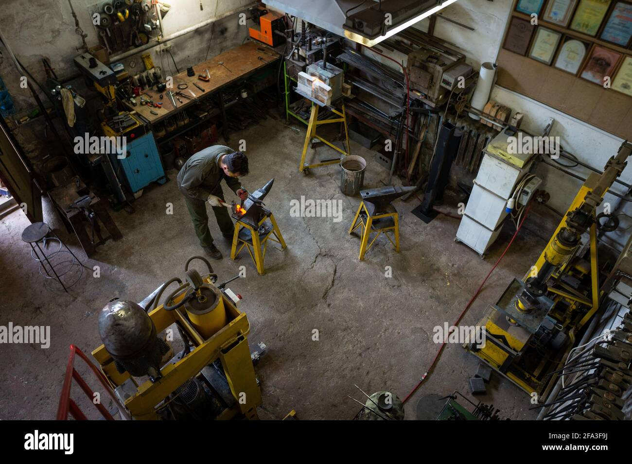 Traditional metalworking process in a forge.The master blacksmith works ...
